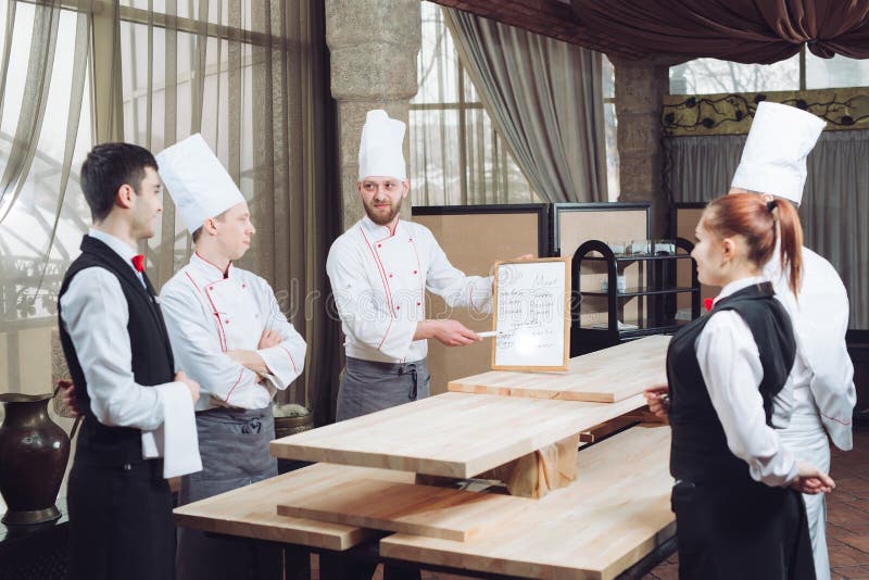 Restaurant Manager and His Staff in Kitchen. Interacting To Head Chef ...
