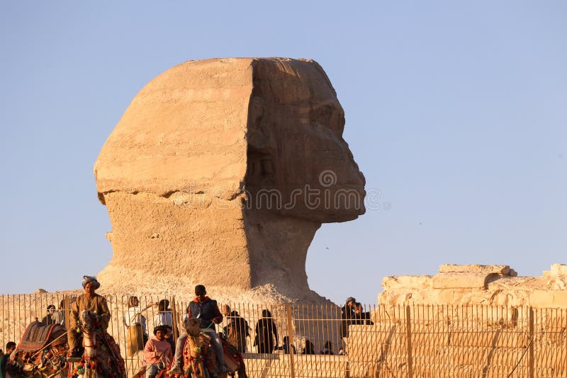 The Head of the Sphinx at Sunset with Tourists on Camels in the ...