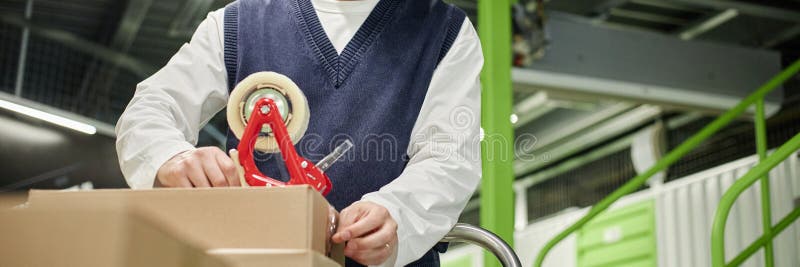 Man Sealing Parcel with Tape Dispenser in Warehouse Setting Stock Image ...