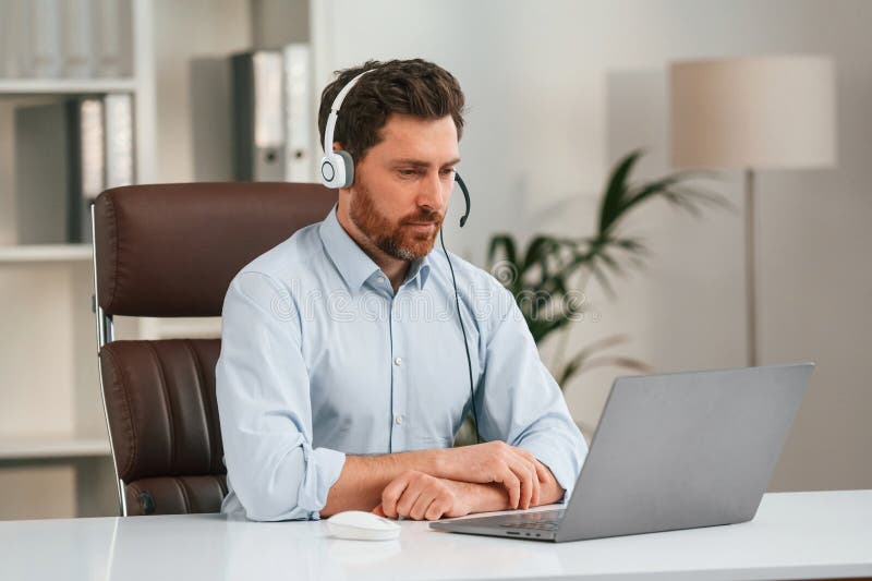 In Headphones. Doctor in Formal Clothes is Working in the Cabinet Stock ...