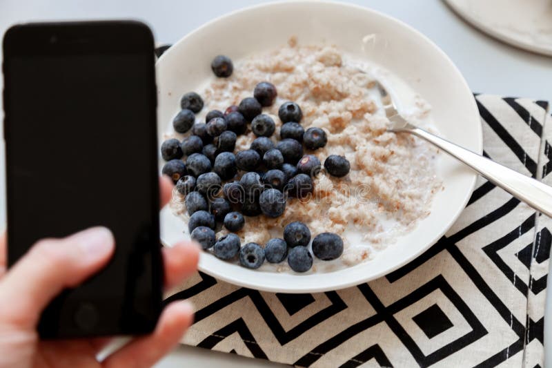 Healthy Breakfast with Oatmeal, Blueberries and a Smartphone Stock ...