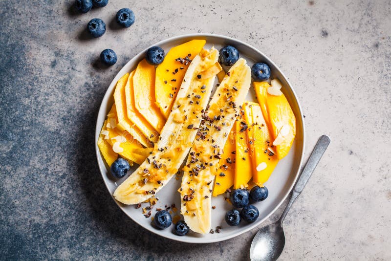 Healthy Vegan Banana Split with Mango and Chocolate on Gray Plate, Top ...