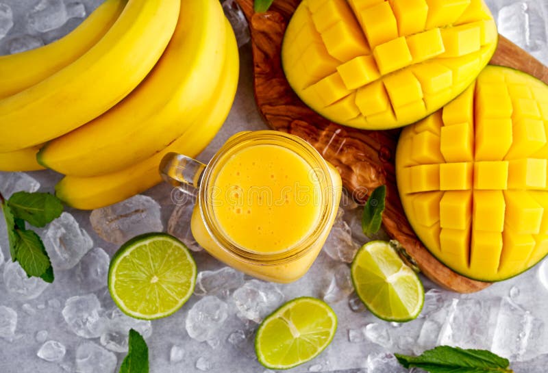 Healthy Yellow Banana Mango Smoothie with Slices of Lime, Mint and Ice ...