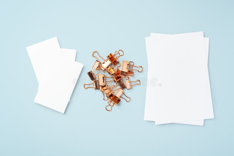 Heap of Gold Binder Clips and Memo Note Paper on Light Blue Background ...