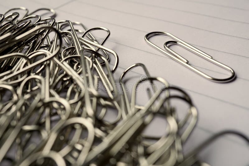 Heap of Metal Paper Clips on White Lined Paper Notepad As a Symbol of ...