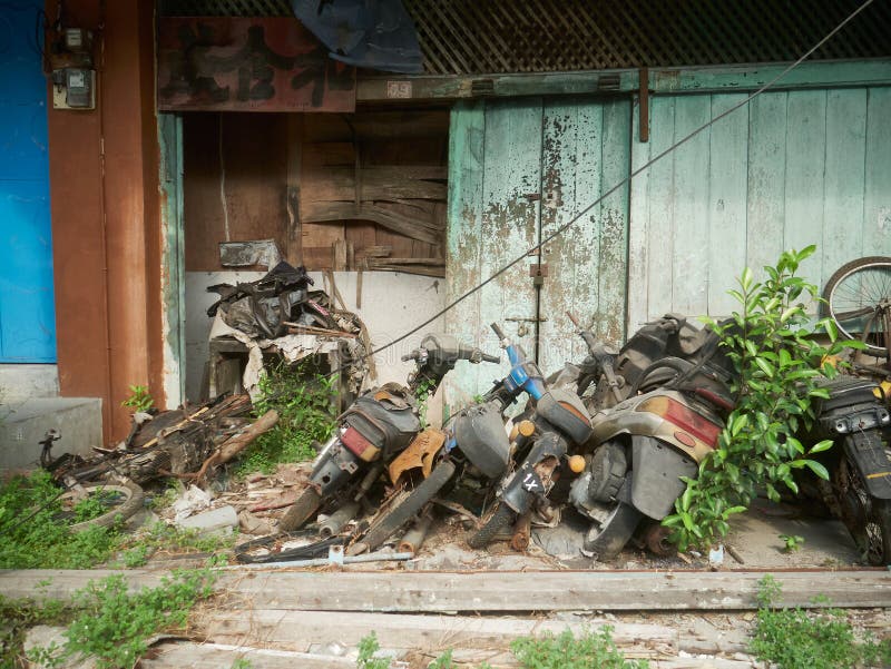 A Heap of Rusty Motorcycles Left in Front of an Old Wooden Shop Stock ...