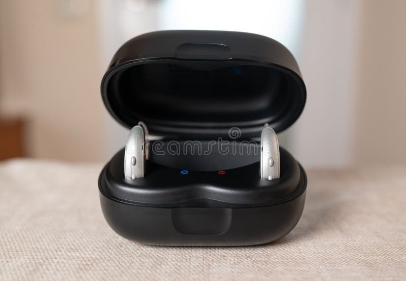 Hearing Aid Devices Charging in Black Case on Table Stock Image - Image ...