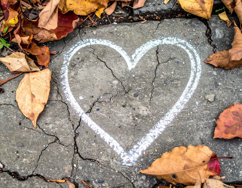 A Heart Drawn in Chalk on Cracked Concrete Surrounded by Dried Leaves ...