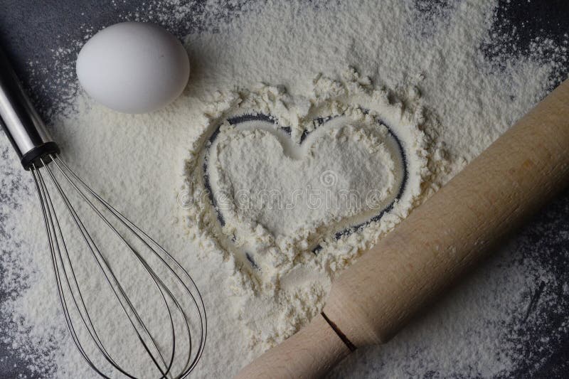 A Heart is Drawn on the Sifted Flour and a Rolling Pin Next To it and ...