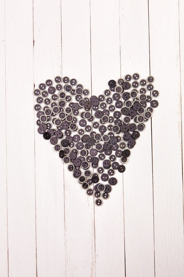 Heart Laid Out from the Buttons on a White Background Wooden Table ...