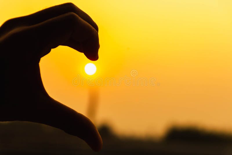 Heart Made with Hand and the Orange Sun is the Background Stock Photo ...