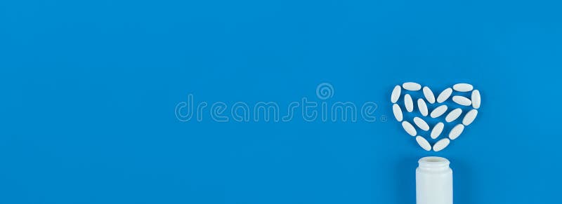Heart Shape Made from White Tablets and Medical Bottle on Blue Backdrop ...