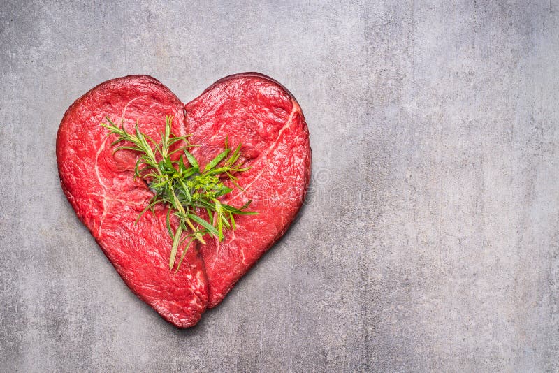 Heart Shape Raw Meat with Herbs and Text on Gray Concrete Background ...