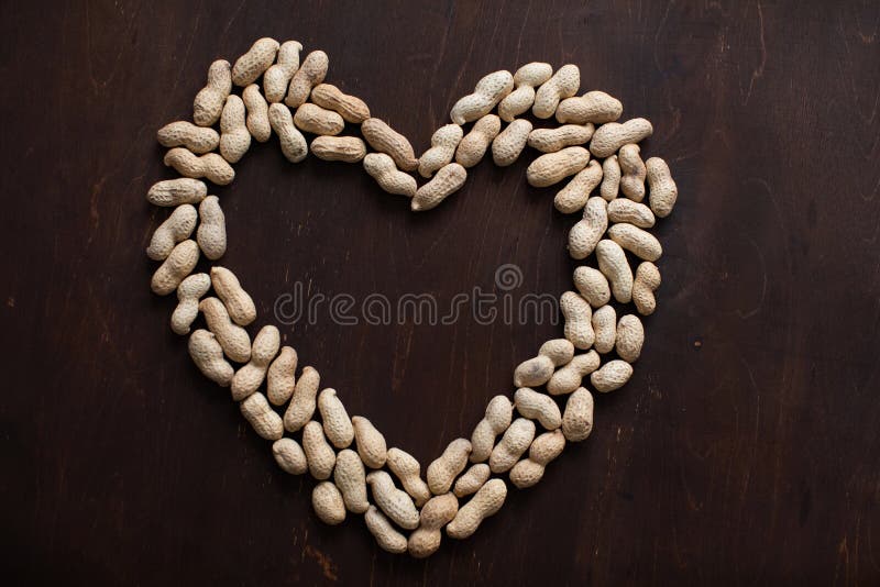 Heart Shaped Peanuts on a Brown Wooden Table Stock Photo - Image of ...