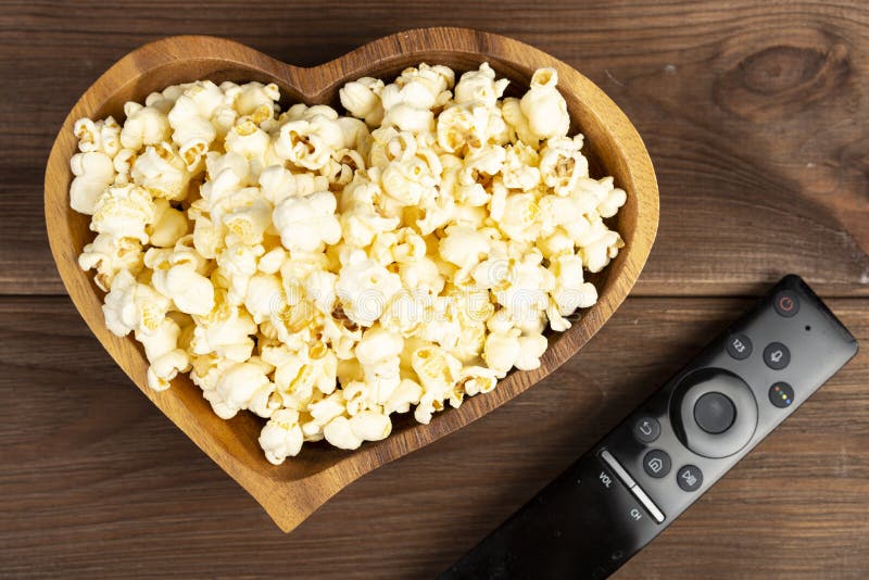 Heart Shaped Popcorn in a Wooden Bowl and a Television Remote Control ...