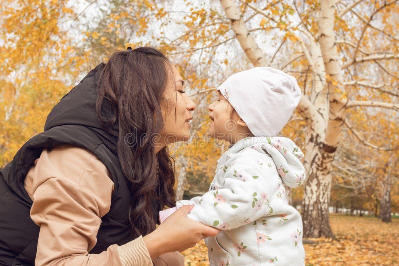 Heartwarming Scene of Mother and Child Playfully Interacting in a Fall ...