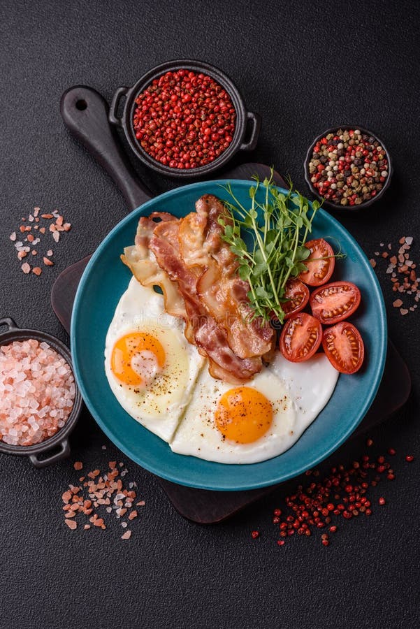 A Hearty Breakfast with Fried Eggs, Bacon, Tomatoes, Microgreens Stock ...