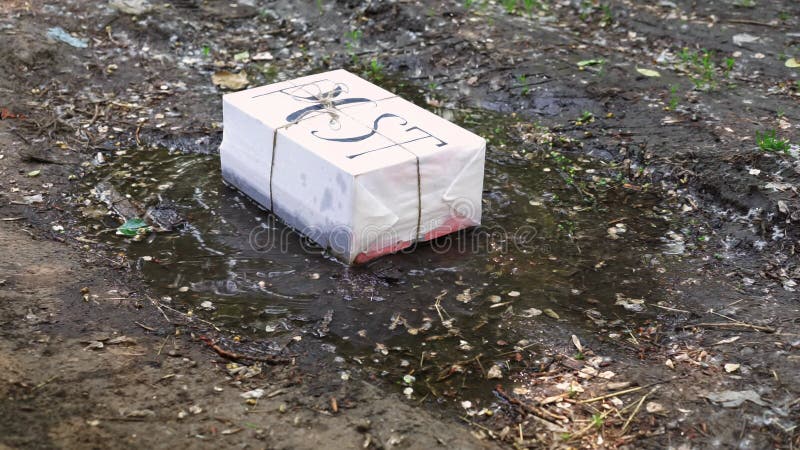 Heavy Box Labeled As POST Falls in Centre of Small Puddle Stock Footage ...