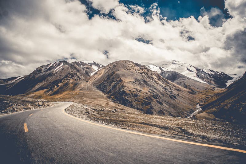Heavy Clouds and High Mountains with Long Route Road Stock Photo ...