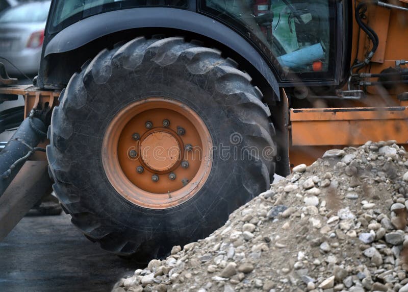 Heavy Duty Backhoe Wheel with Large Rock Pile Stock Photo - Image of ...