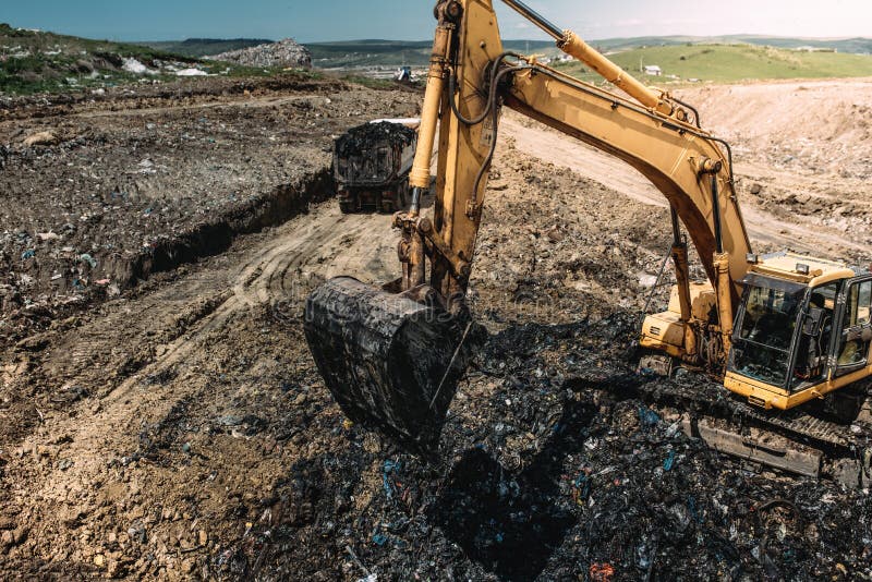 Heavy Duty Machinery, Excavator Digging Hole and Loading Garbage into ...