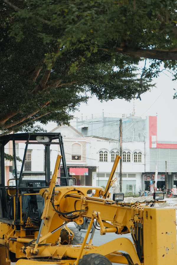 A Heavy Equipment Machine Like a Bulldozer Under a Tree Near a ...