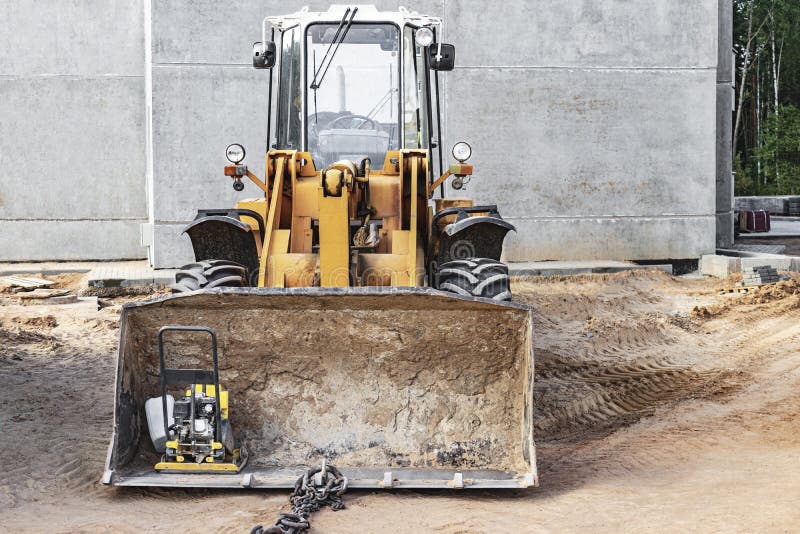 Heavy Front Loader on a Construction Site with a Construction Tool in ...