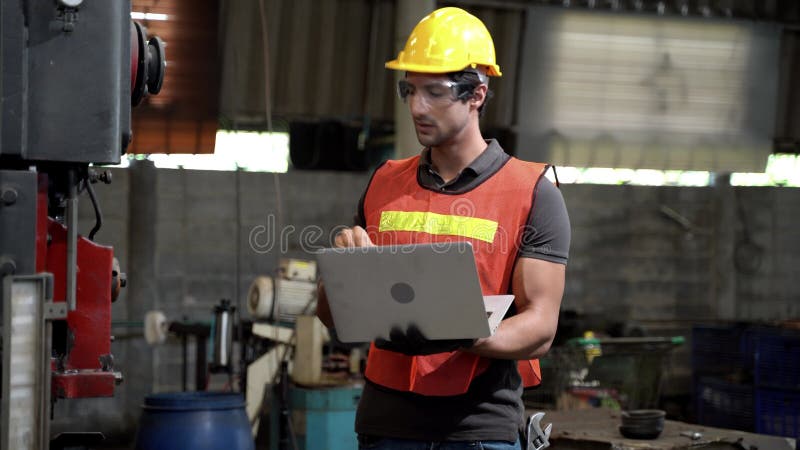 Heavy Industry Worker Man with Laptop Computer is Checking and ...