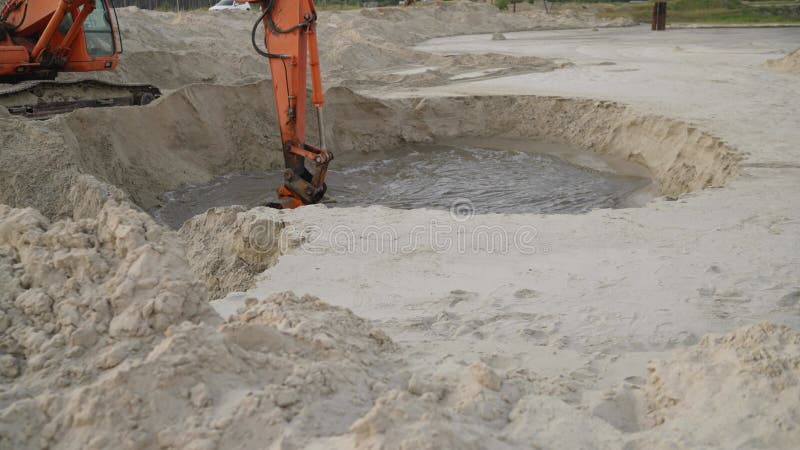 Excavator Digging and Filling a Hole with Sand and Water Stock Footage ...
