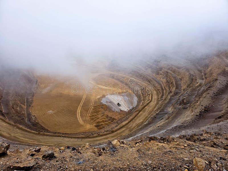 Heavy Machinery Working at the Bottom of an Open Pit Mine on a Day with ...