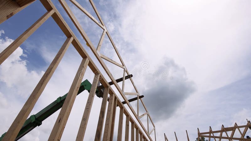 Construction Workers Using Telehandler Machinery To Lift Wooden Beams ...