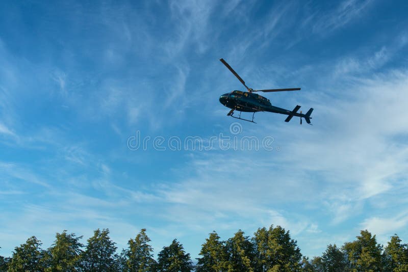 Helicopter Flying Over the Forest in the Sky with Clouds Stock Photo ...