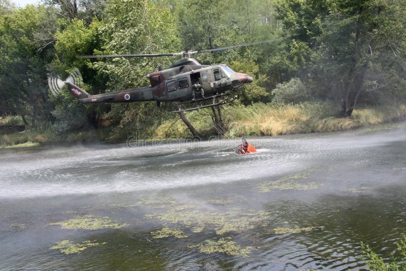 Helicopter Gathering Water from River To Extinguish a Fire Stock Photo ...