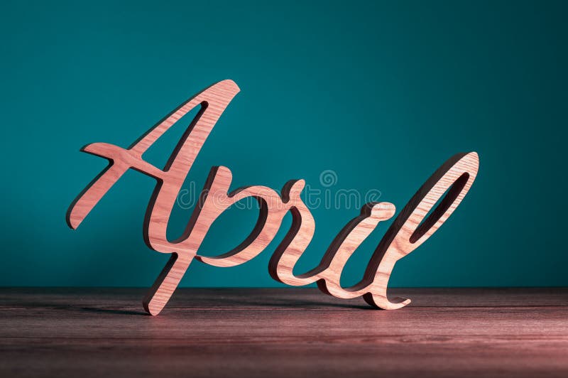 April - Wooden Carved Word on Yellow Background. Spring Time, 1st of ...