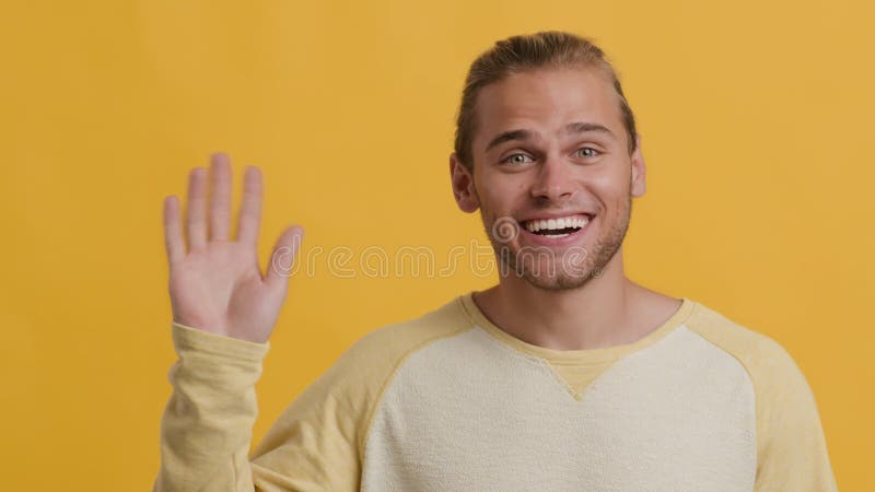 Hello. Friendly Young Guy Waving Hand at Camera, Standing on Yellow ...