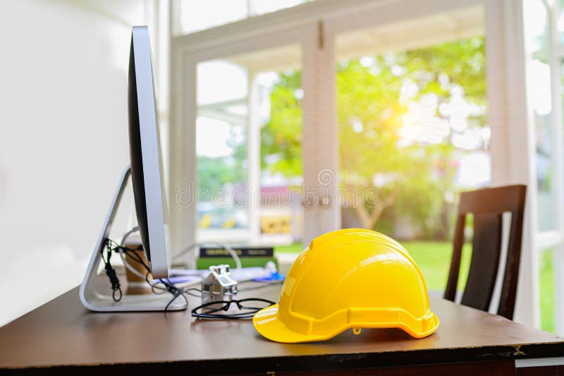 Yellow Helmet on the Desk with a Computer. Stock Image - Image of ...