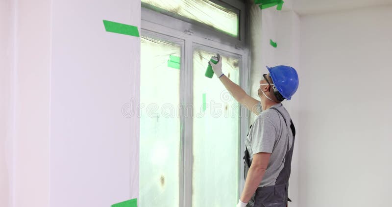 Helmeted Builder Spraying Grey Paint on Window Frame Stock Video ...
