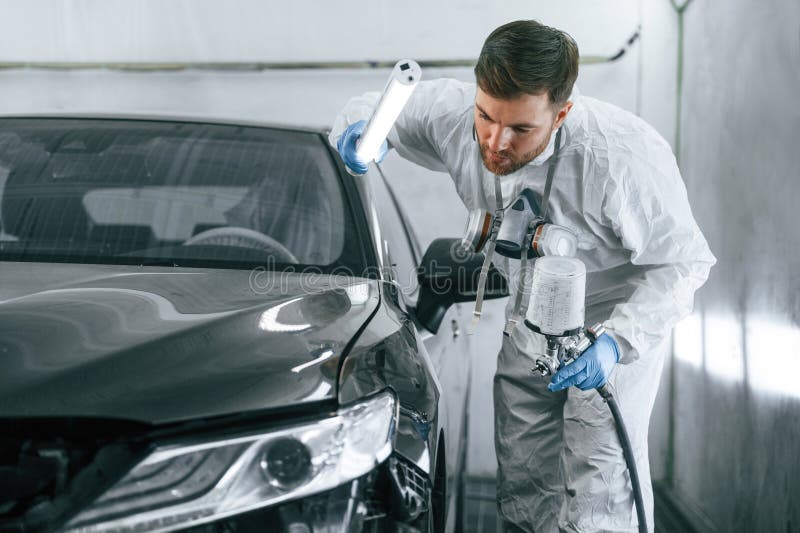 By Help of Lighting Equipment. Man is Painting a Car by Using Spray Guy ...