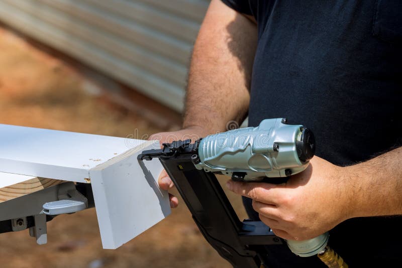 With the Help of a Pneumatic Air Gun, the Carpenter Connects the ...