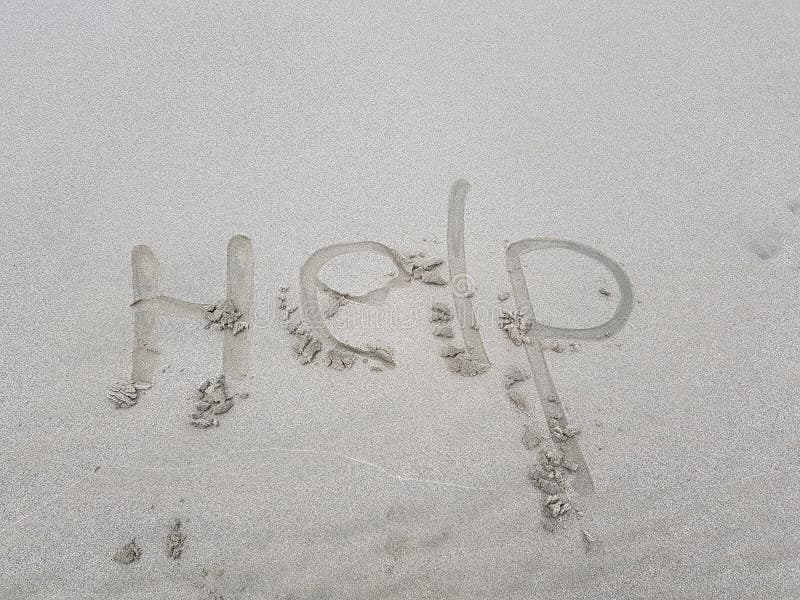 Help sign written on sand stock photo. Image of sign - 199987386