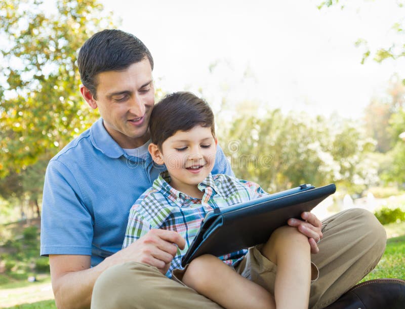 Helpful Father Playing with Son on a Computer Tablet Outside. Stock ...