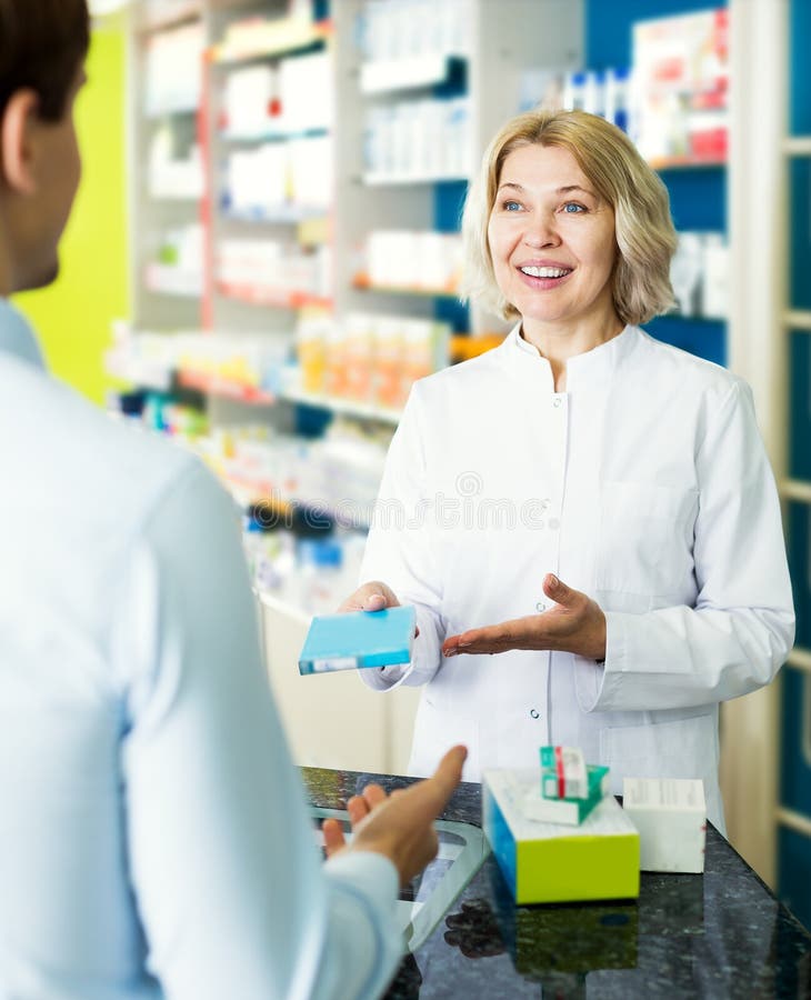 Helpful Pharmacist Serving and Consulting Man Stock Photo - Image of ...