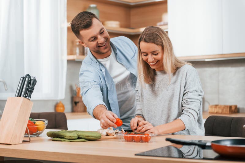 Helping Each Other. Couple Preparing Food at Home on the Modern Kitchen ...