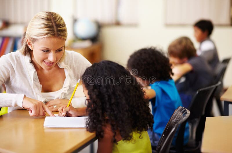 Helping Them To Understand. a Young Teacher Helping Children with Their ...