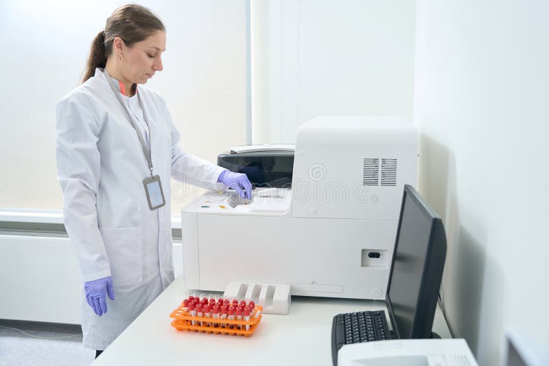 Hematologist Laboratory Assistant Stands Near an Immunochemiluminescent ...