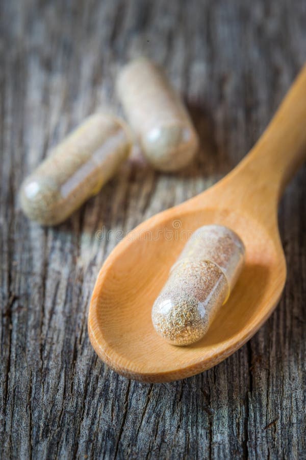 Herb Capsules Spilling in Wooden Spoon. Stock Photo - Image of illness ...