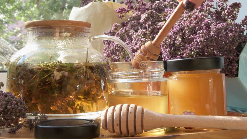 Spilling Herbal Tea with Fresh Natural Honey in Jars in Beautiful Sun ...