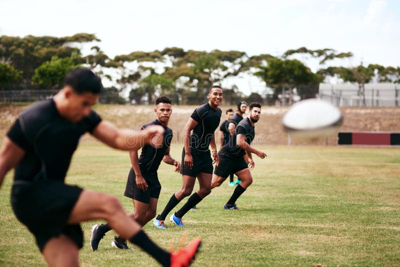 Here Comes the Kickoff. a Group of Young Men Playing a Game of Rugby ...