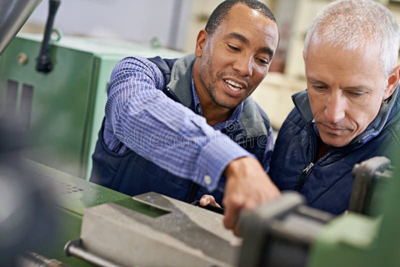 This Here Needs an Adjustment. Two Men Working Over Factory Machinery ...