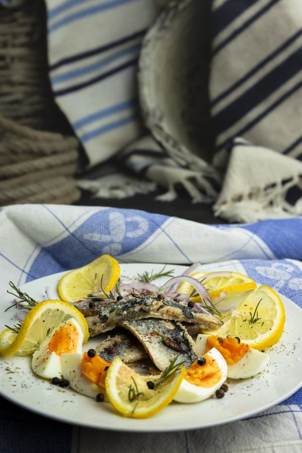 Herring Fish Fillets with Eggs, Herbs, Onion and Lemon on a White Plate ...